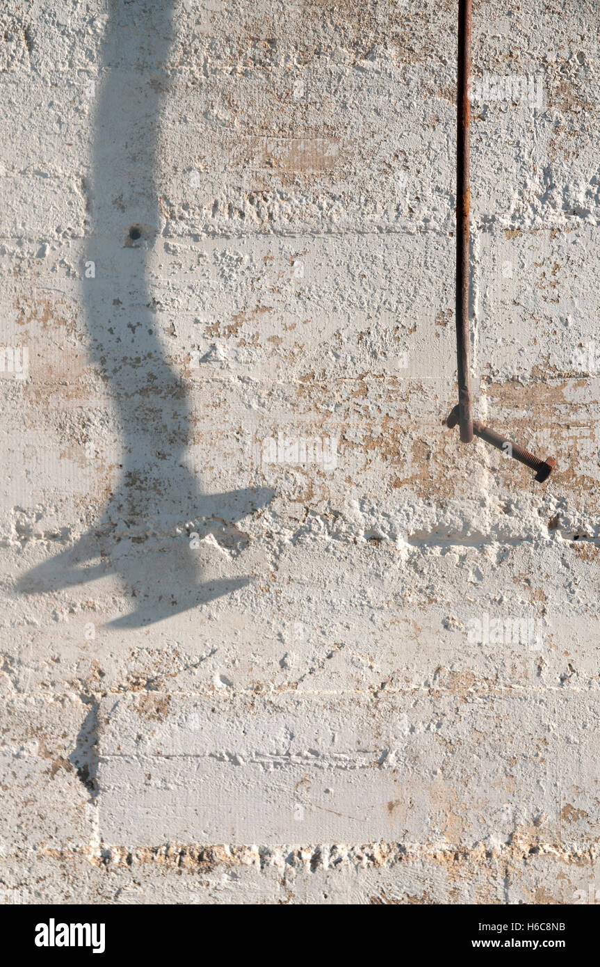 Metal rod casts a shadow on a wall in the morning light Stock Photo - Alamy