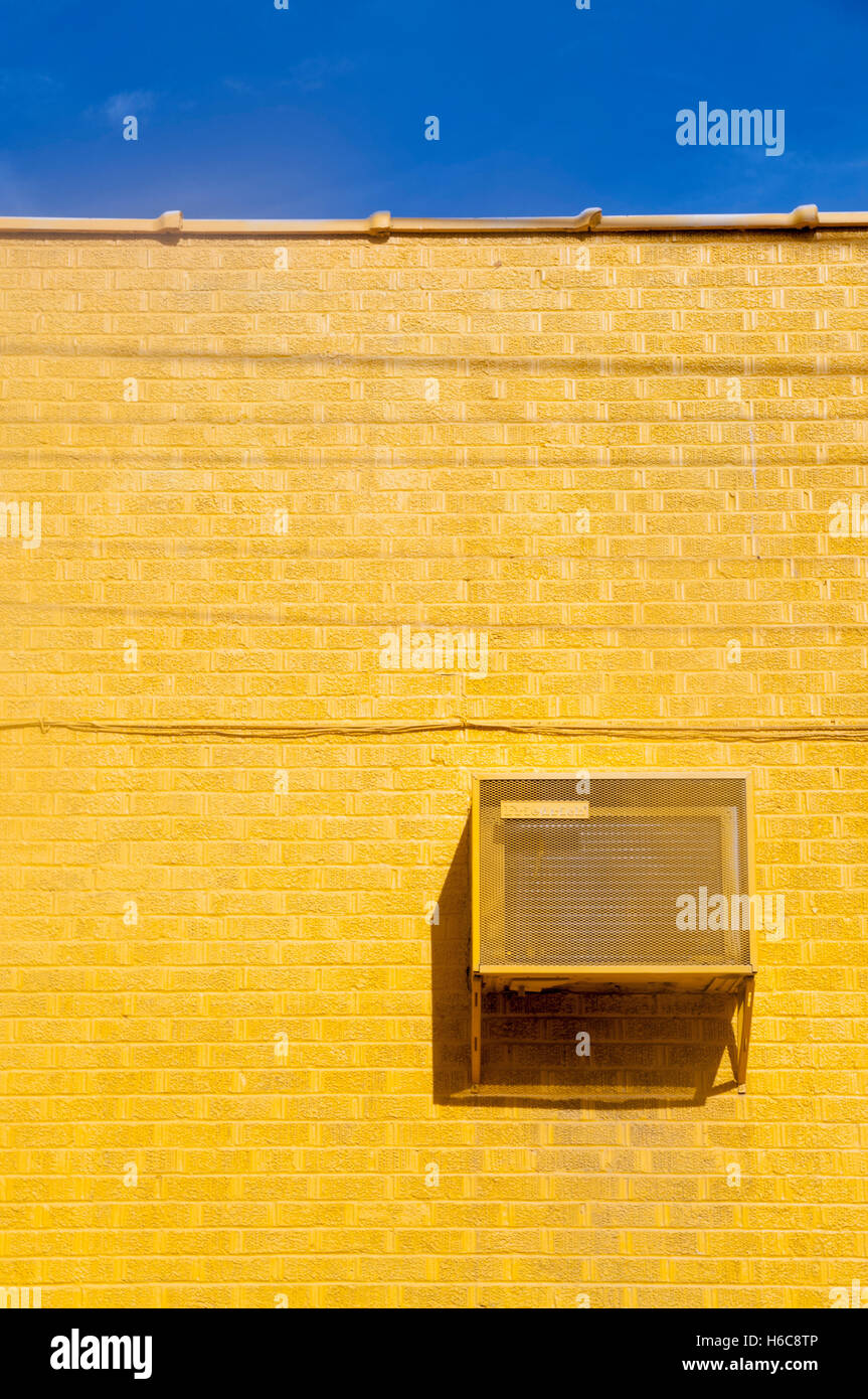 Bright yellow painted wall with air conditioning unit Stock Photo - Alamy