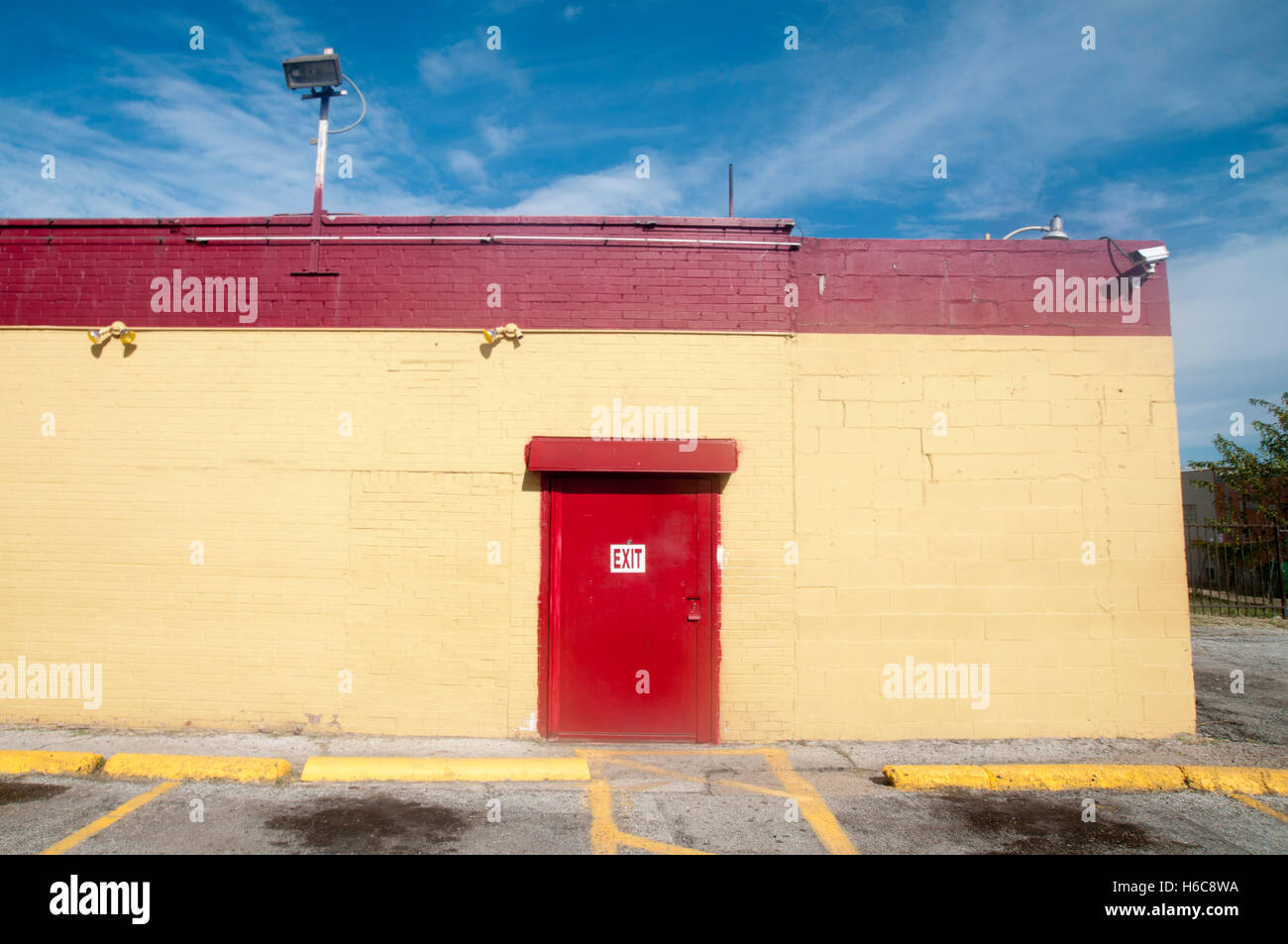 Yellow wall with a red exit door Stock Photo - Alamy