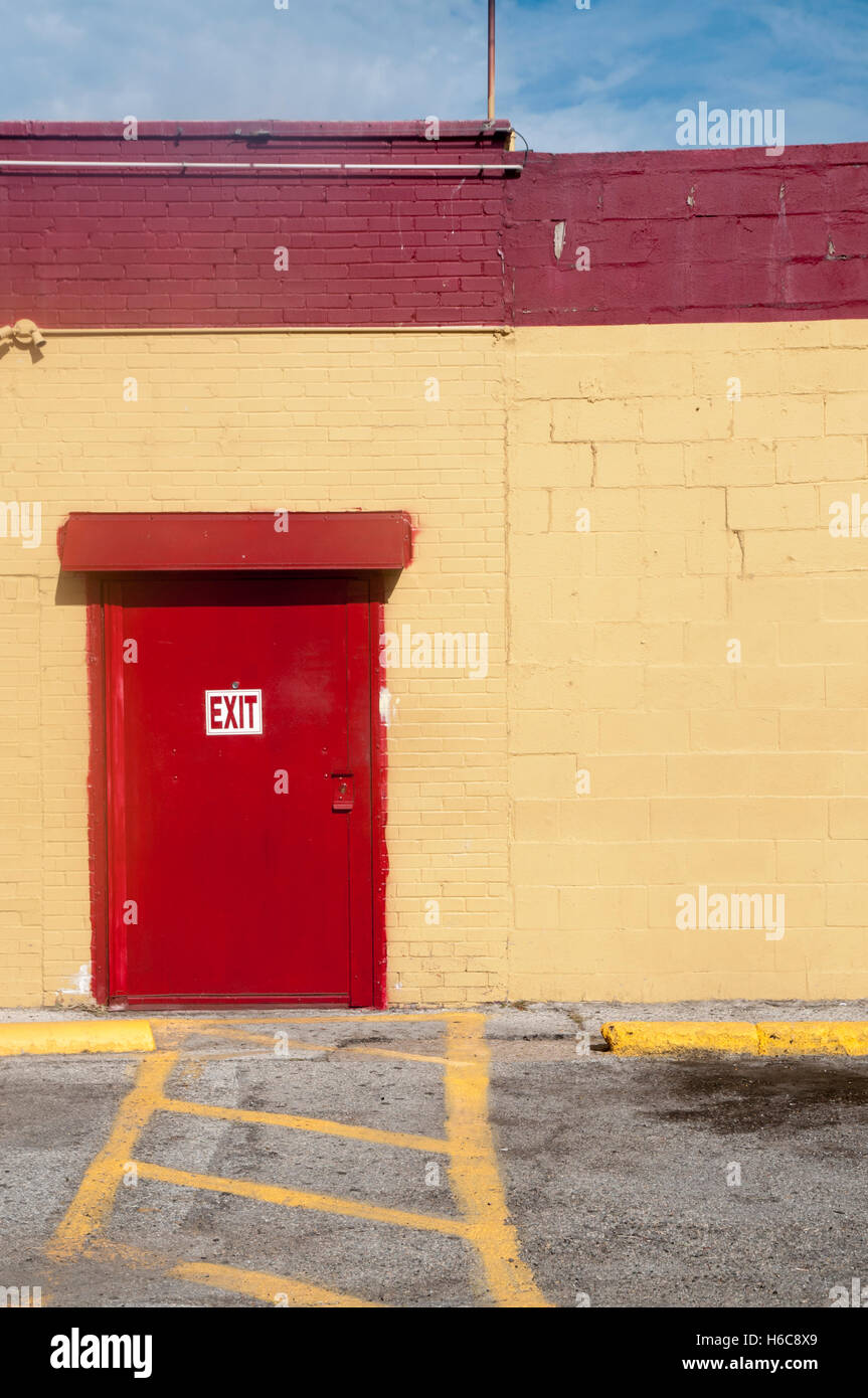 Yellow wall with a red exit door Stock Photo - Alamy