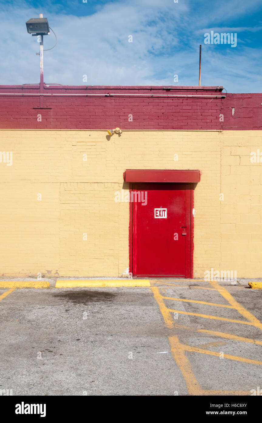 Yellow wall with a red exit door Stock Photo - Alamy
