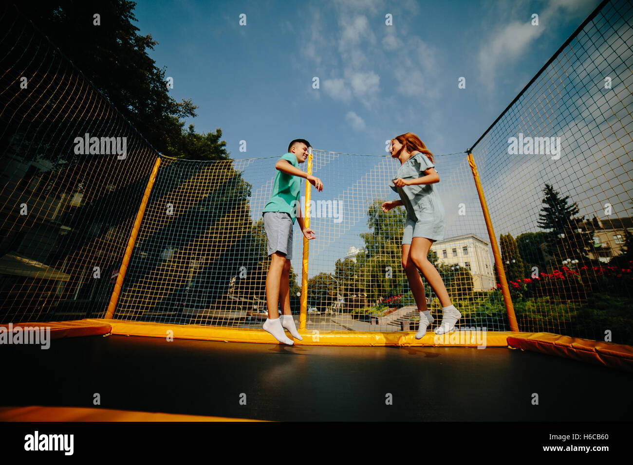 Woman jumping on trampoline outdoors hi-res stock photography and ...
