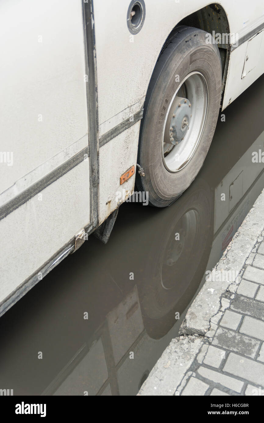 Wheel white bus in a puddle. bus stops in the fall Stock Photo - Alamy