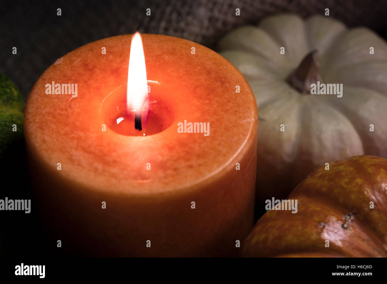 Fall theme close up of orange candle burning with gourds Stock Photo ...