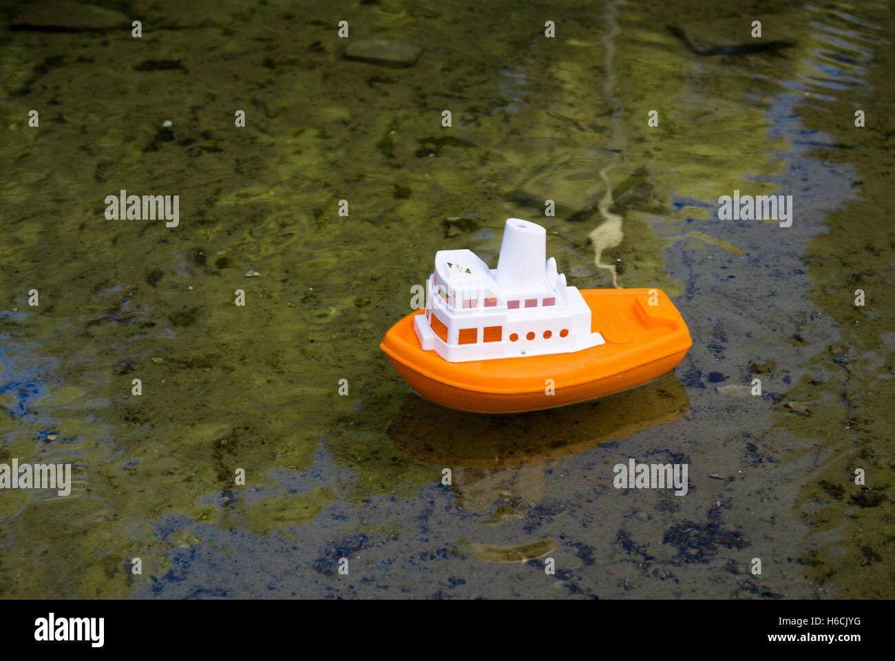 Toy ship floating on the river Stock Photo - Alamy