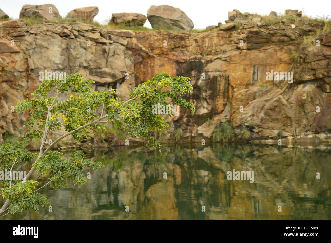 Rock wall reflected in lake water Stock Photo - Alamy