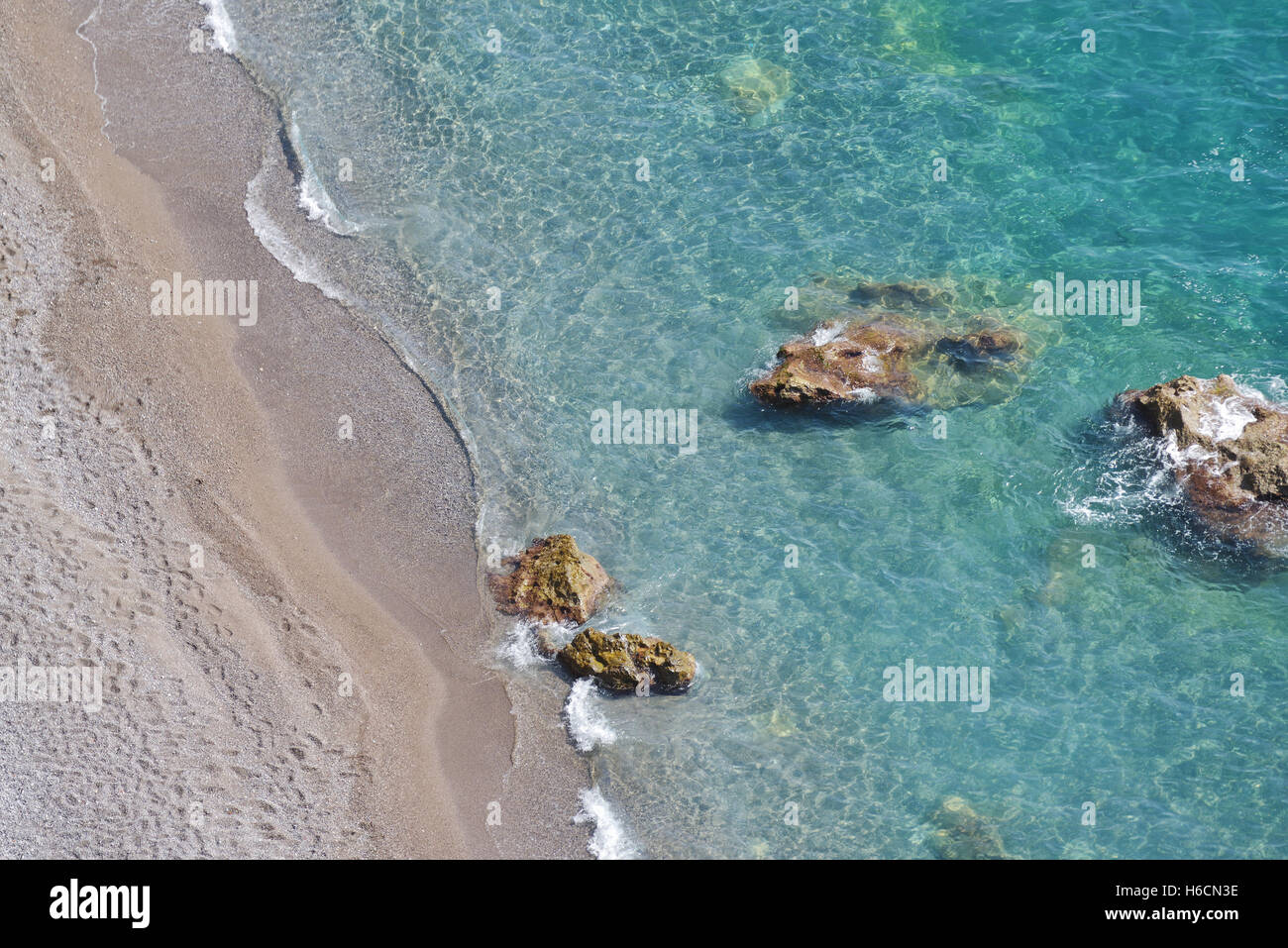 Top view of a beach with golden sand, rocks and clear blue water Stock ...