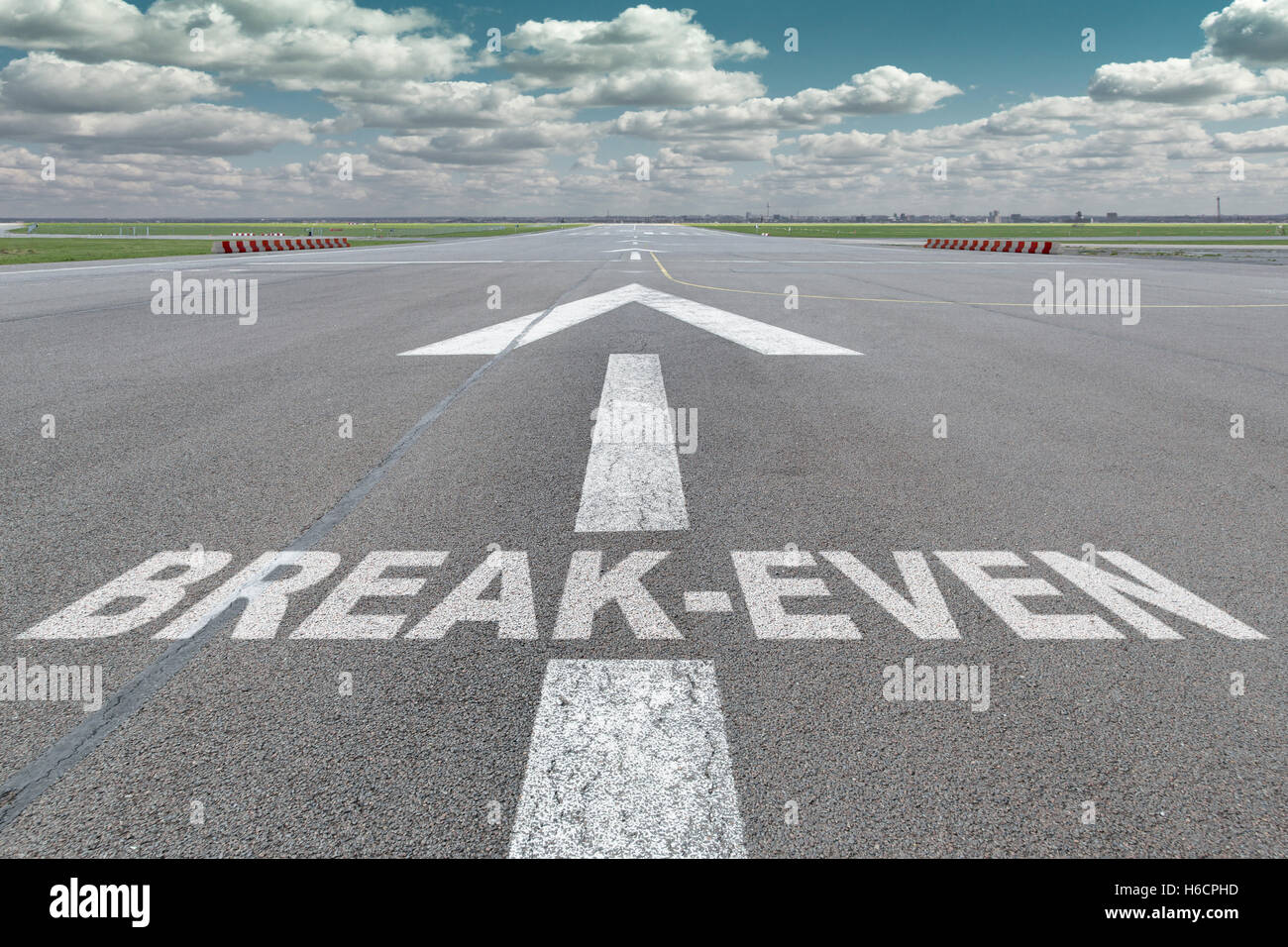 Runway of airport with arrow guideline and BREAK-EVEN letters painted ...