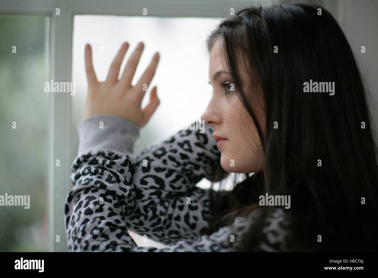 Young woman at window, pensive, sad Stock Photo - Alamy