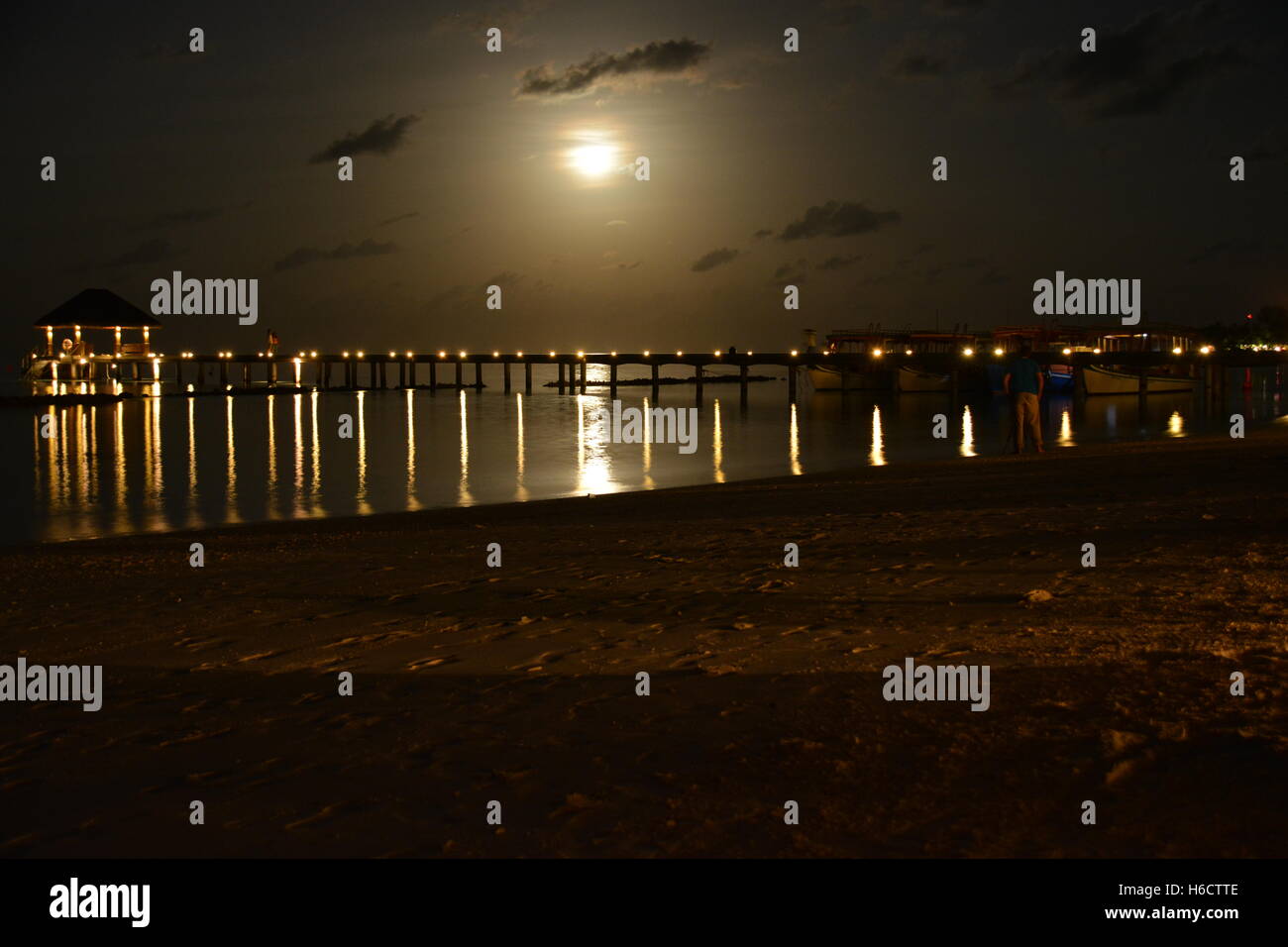 Maldives night water lights pontoon moon reflection Stock Photo - Alamy