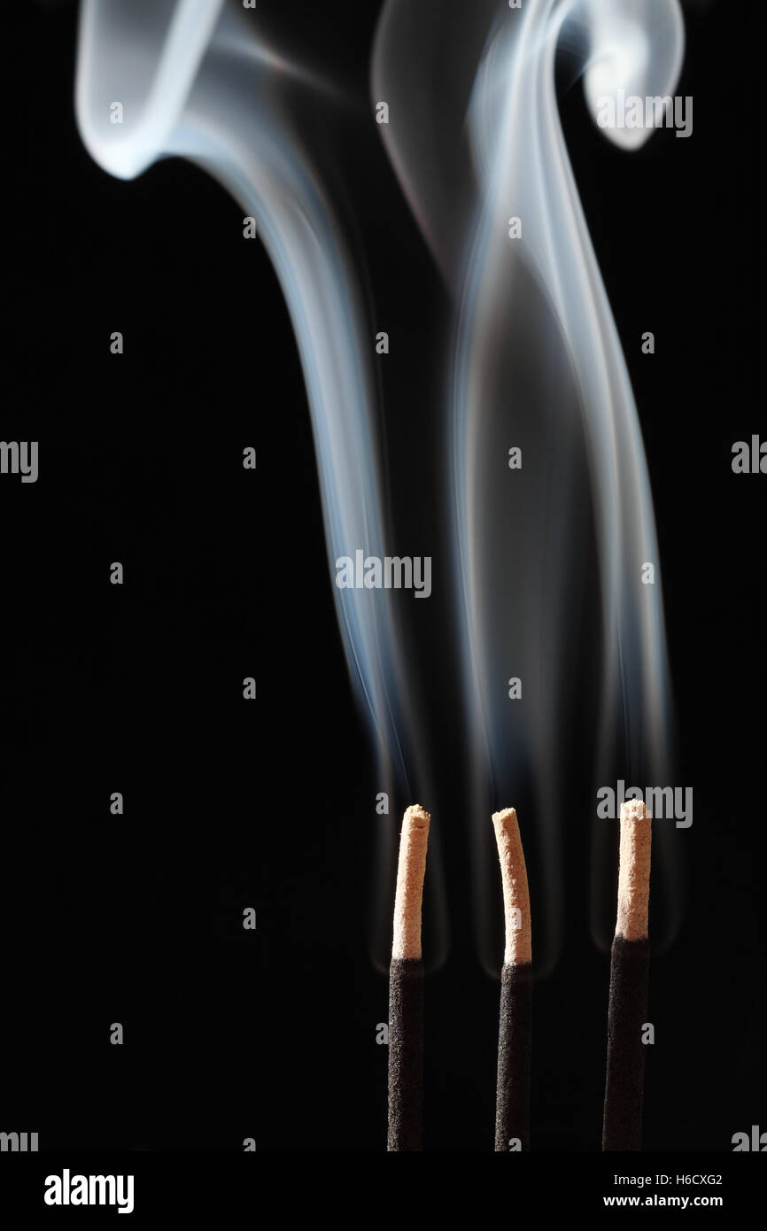 Smoke rising from three incense sticks Stock Photo - Alamy