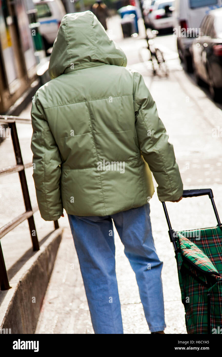 Rear view of a pedestrian walking on an urban pavement at winter Stock ...