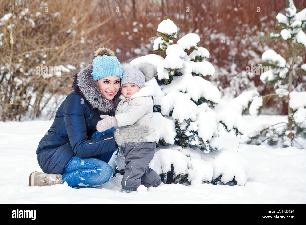 Mother And Young Daughter Embracing In A Winter Park Mother And