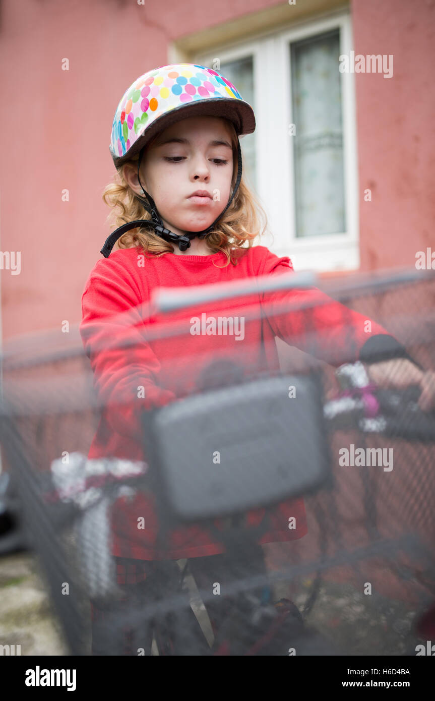 Little girl with her bicycle outdoors. She is looking down Stock Photo ...
