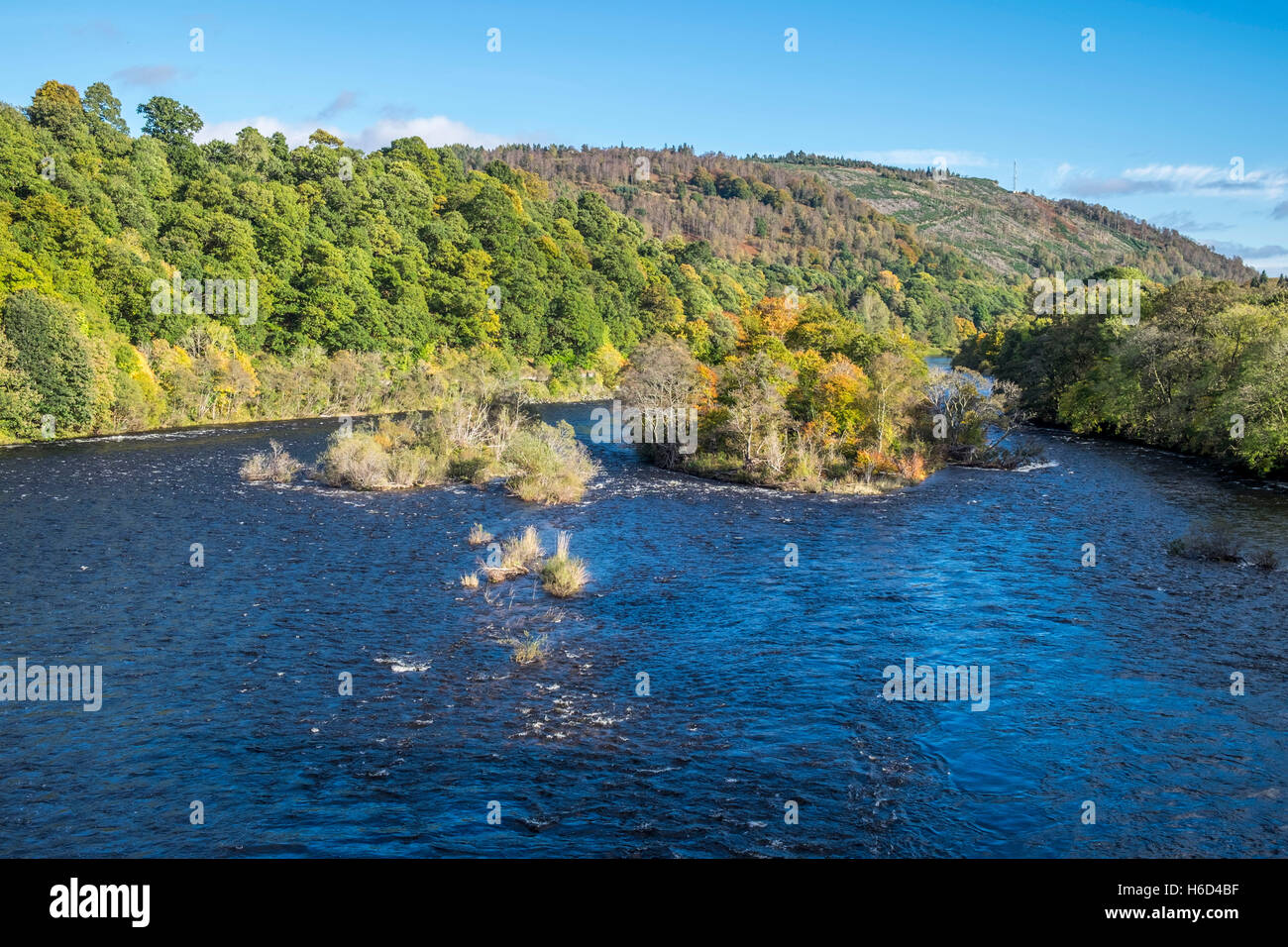The River Tay in Scotland flowing around a small island of trees and ...