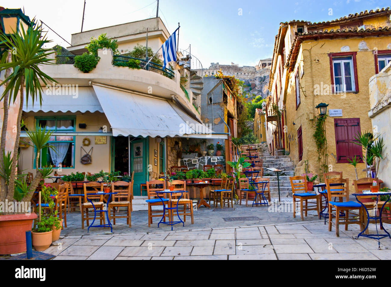 The old greek cafe surrounded by tiny tables in the yard, with a view ...