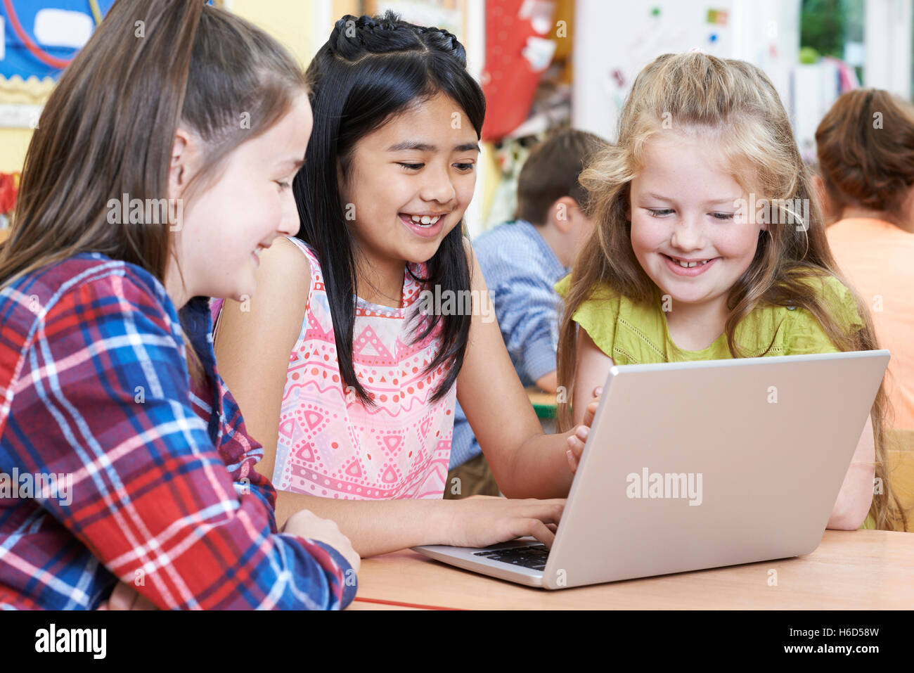 Group Of Elementary School Children Working Together In Computer Class ...