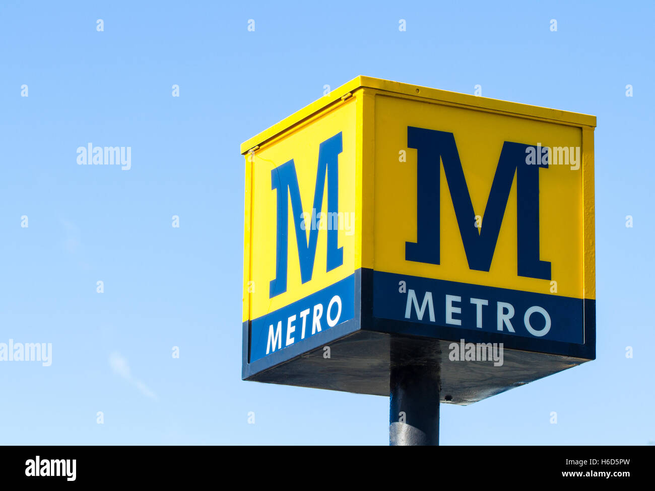 A square, yellow and blue metro sign denoting the entrance to a Metro ...