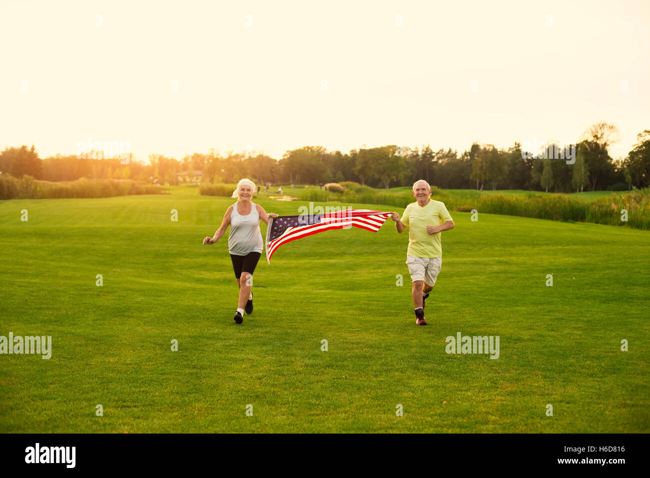 People with American flag running Stock Photo - Alamy