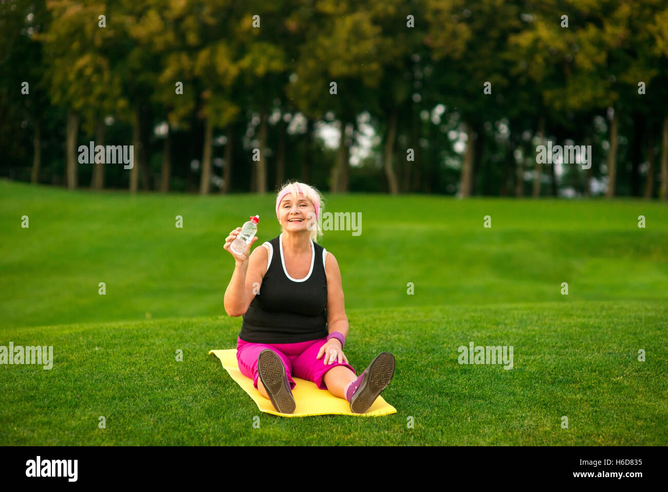 Senior lady sitting on mat Stock Photo - Alamy