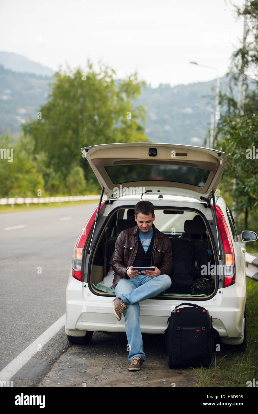 leisure, road trip, travel and people concept - happy man searching ...