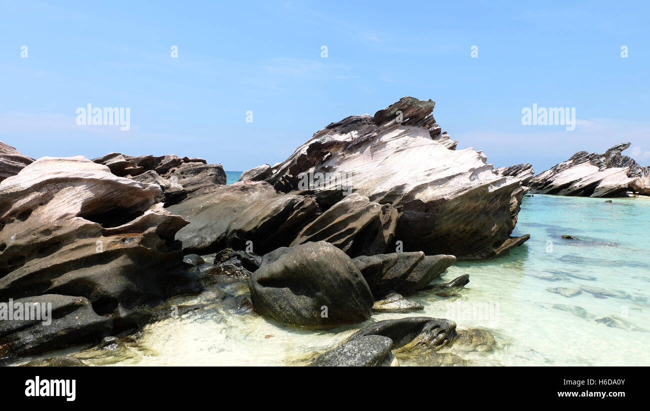 Some brown rocks on the beach in sunny day Stock Photo - Alamy