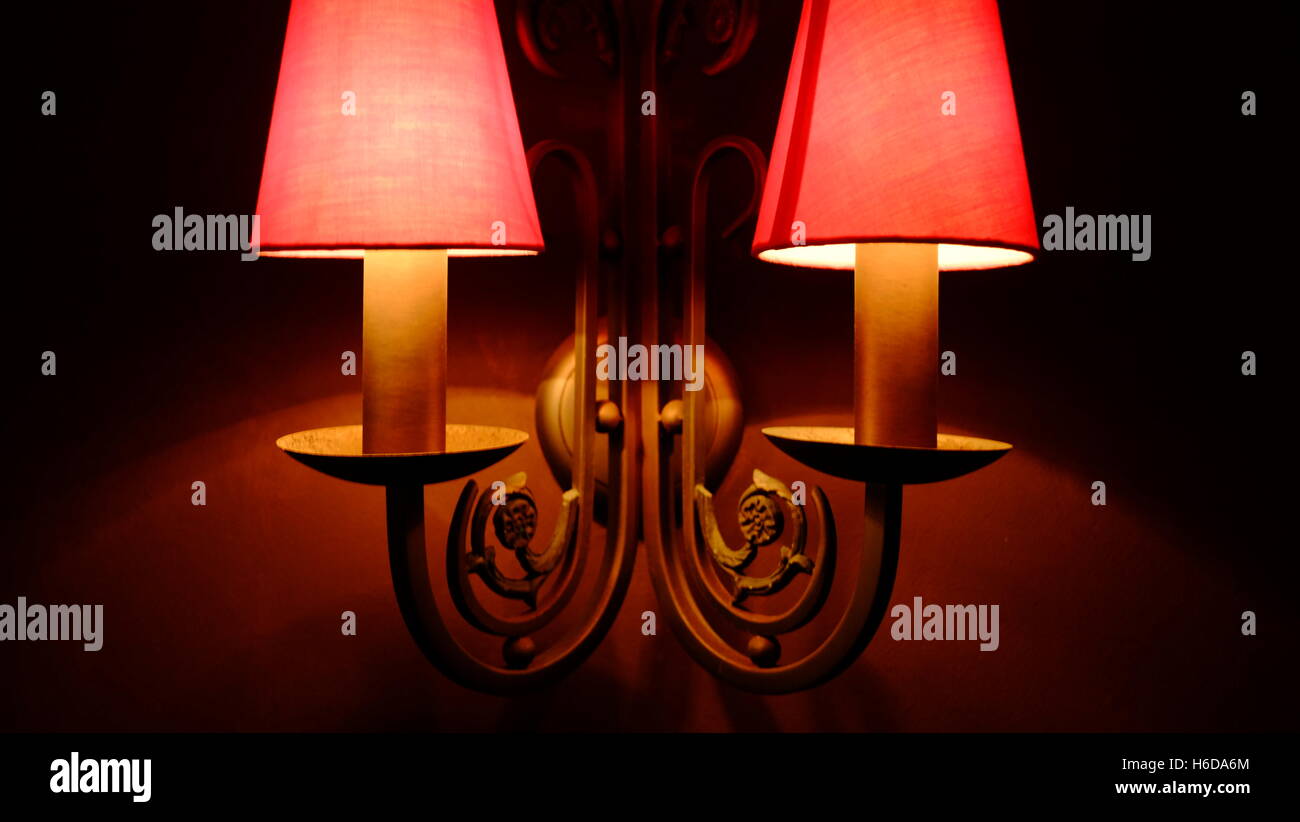 Two red wall lamps and red wallpaper background Stock Photo - Alamy