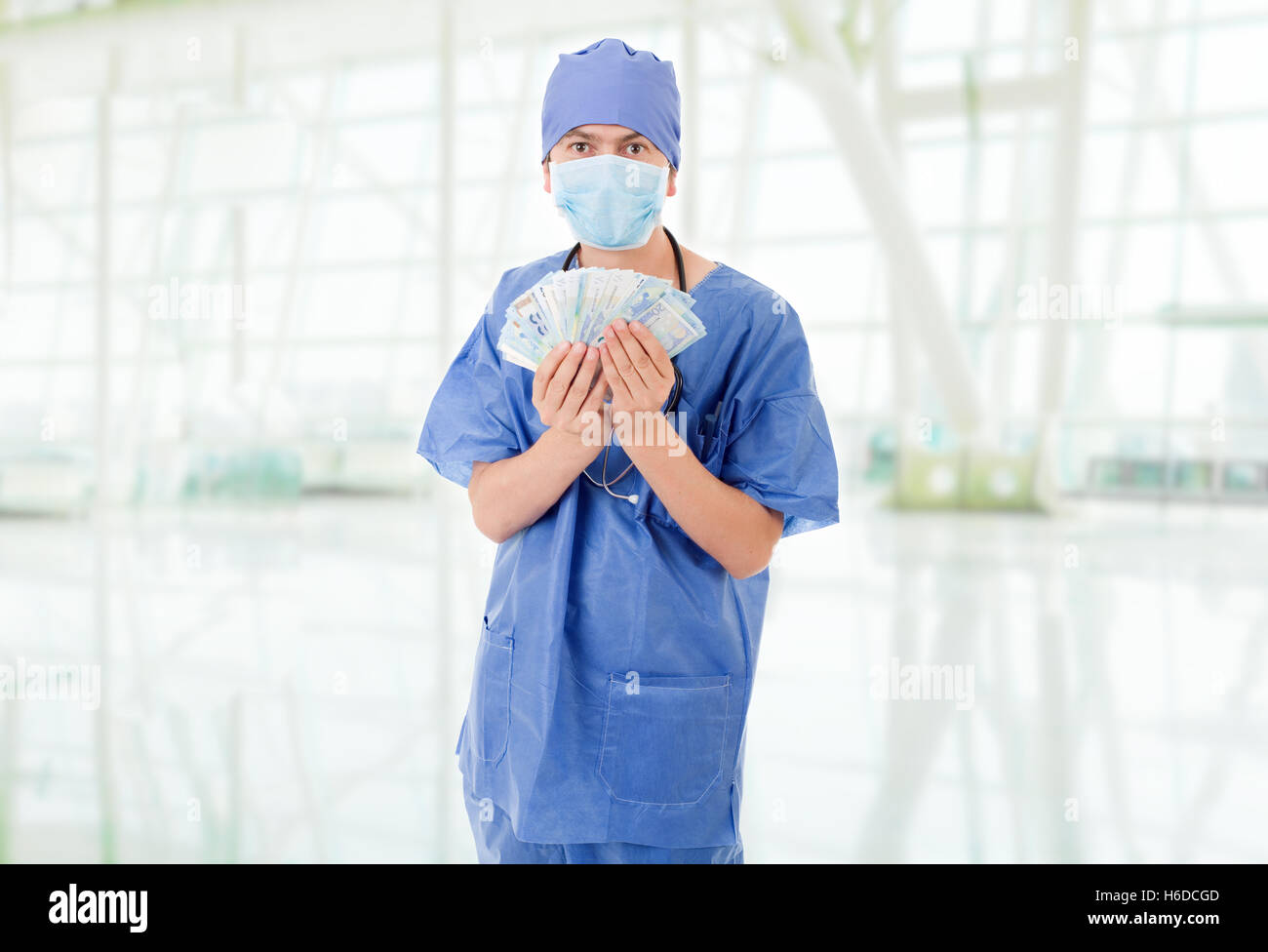 Happy male doctor holding bank notes, at the hospital Stock Photo - Alamy