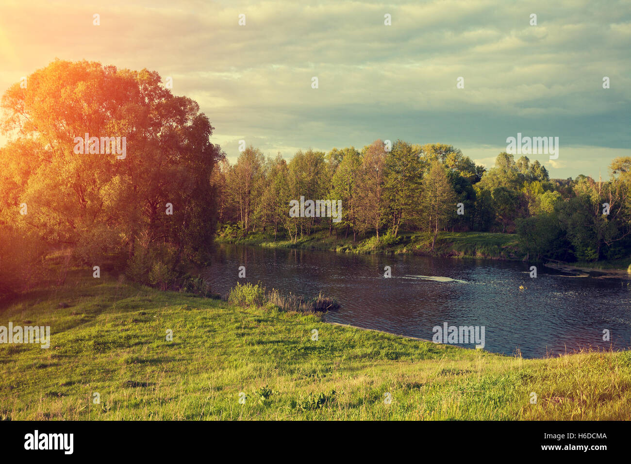 Rural landscape with lake at sunset Stock Photo - Alamy