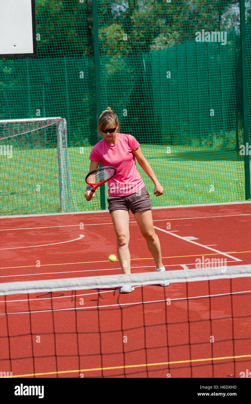 Female tennis player bouncing tennis ball on a court Stock Photo - Alamy