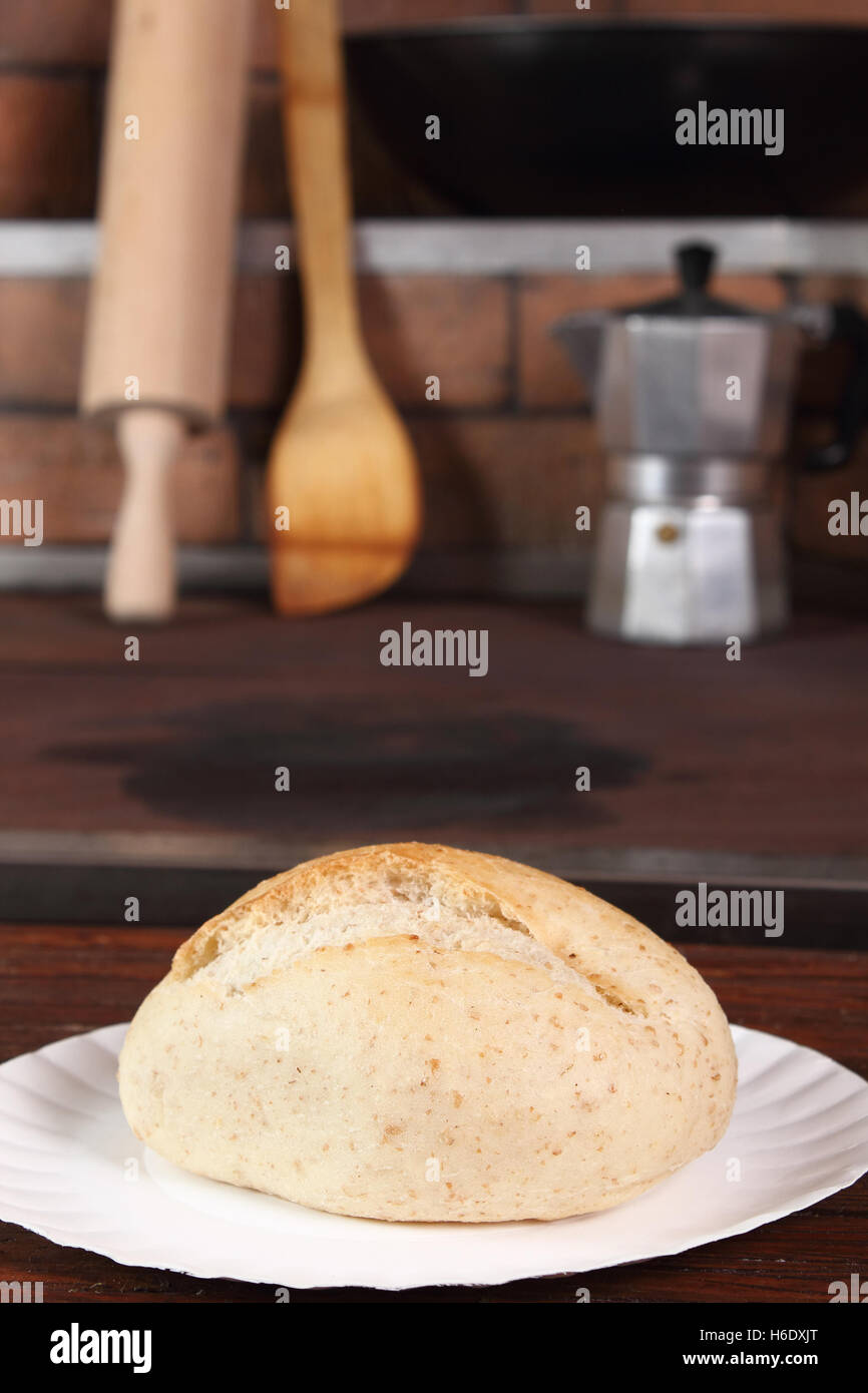 Whole wheat bread roll on paper plate at rural kitchen background Stock ...