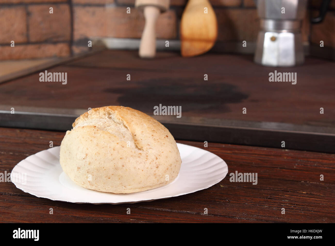 Whole wheat bread roll on paper plate at rural kitchen background Stock ...