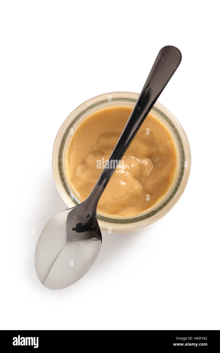 Milk pudding dessert in jar with spoon. Isolated with clipping path ...