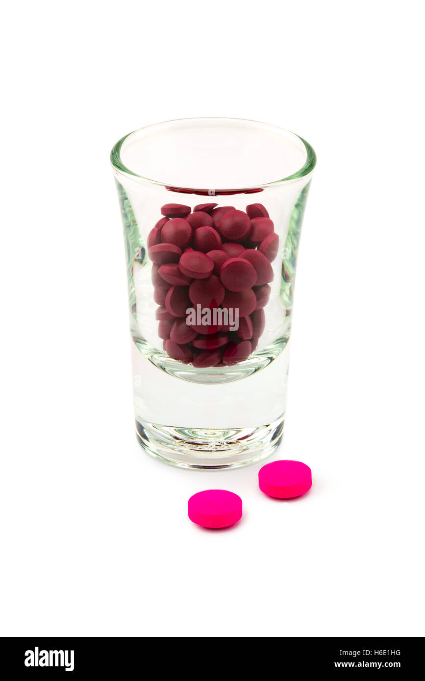 Pills of two kinds of medicine and small glass on white background ...