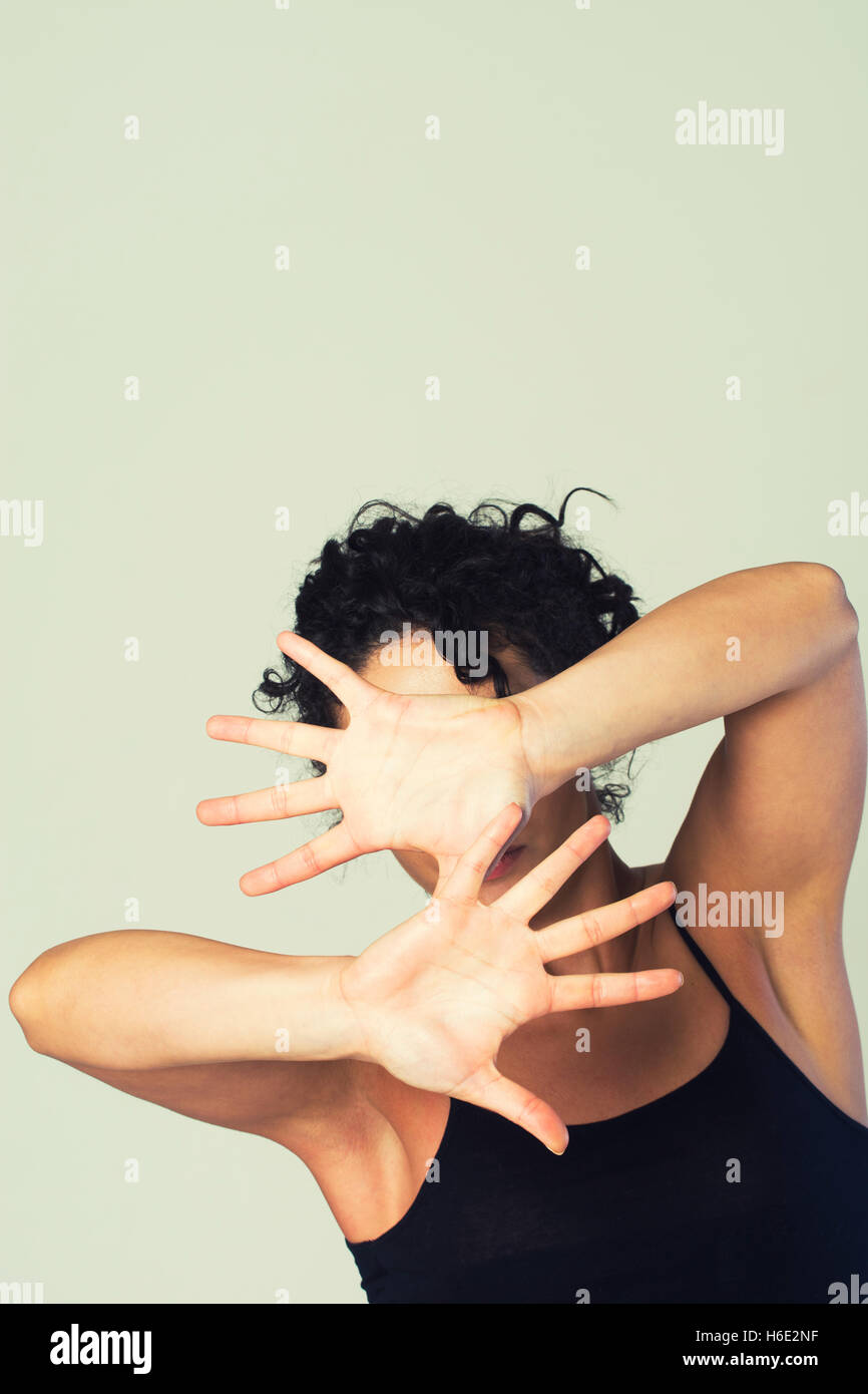 Scared young woman hiding face with hands in fear Stock Photo - Alamy