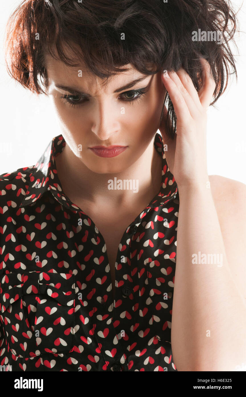 Worried young woman hand on head looking down Stock Photo - Alamy