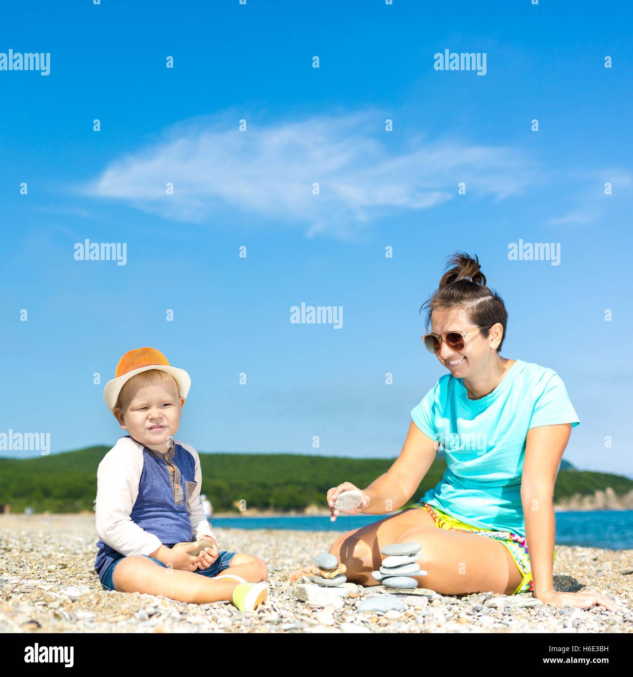 Mother and son making pebble stack near the sea Stock Photo - Alamy
