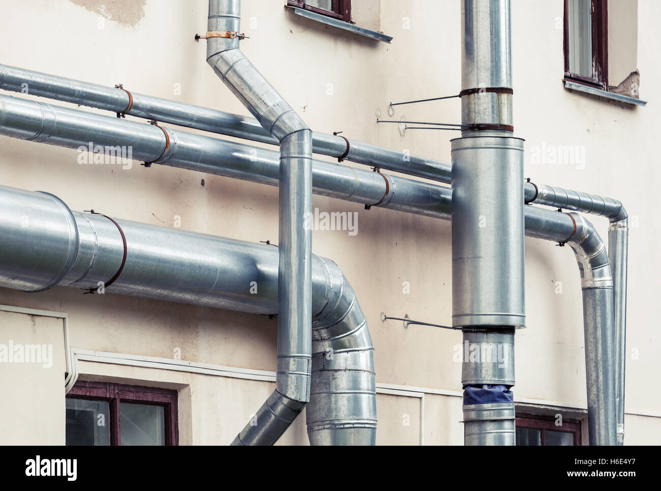 Industrial wall with many external shining ventilation pipes, loft ...