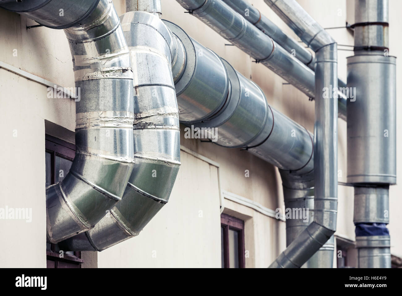 Old wall with many external shining ventilation pipes, loft style ...