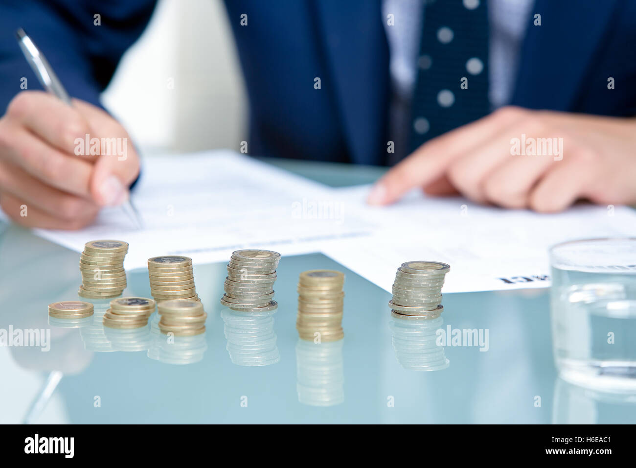 Close up Detail of money coins with hands writing in background. Out of ...