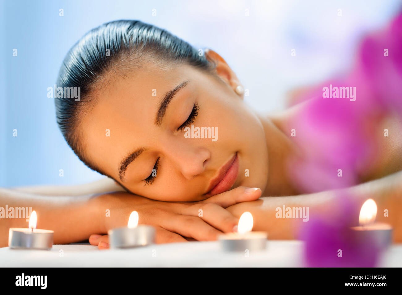 Close up portrait of Young woman relaxing in dimmed candle light after ...
