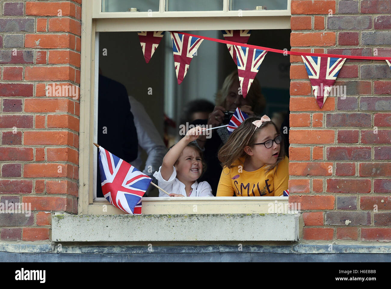 Children look out of a window before Queen Elizabeth II and her husband ...