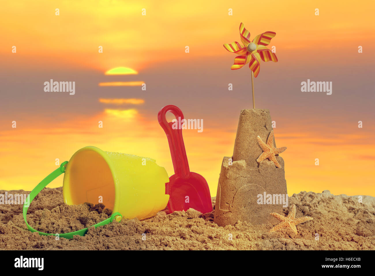 Sandcastle with bucket and spade on the beach at sunset Stock Photo - Alamy