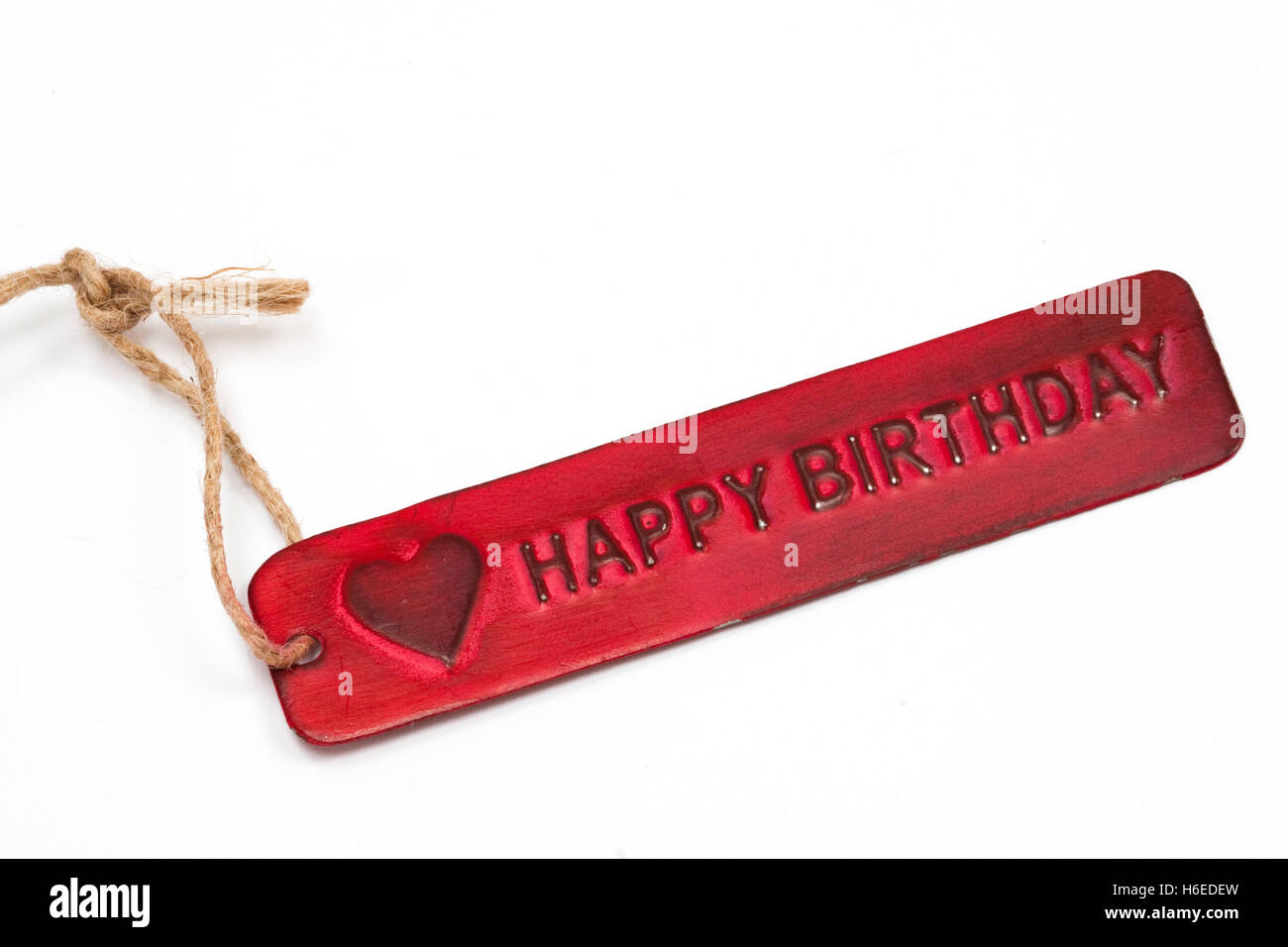 An old red metal label reading happy birthday on a white background ...