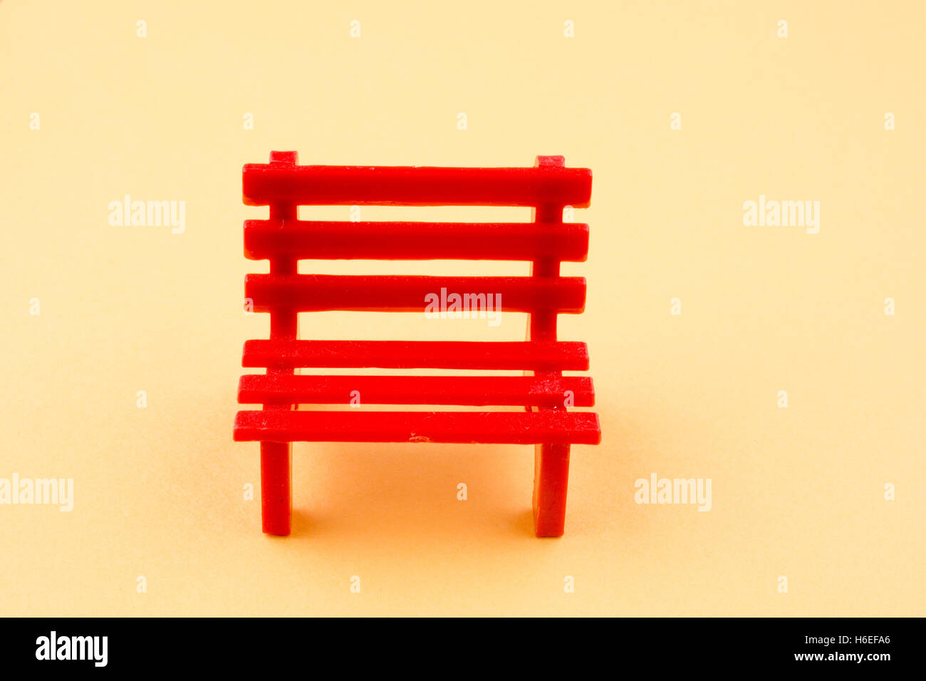 Little red miniature bench made of plastic Stock Photo - Alamy