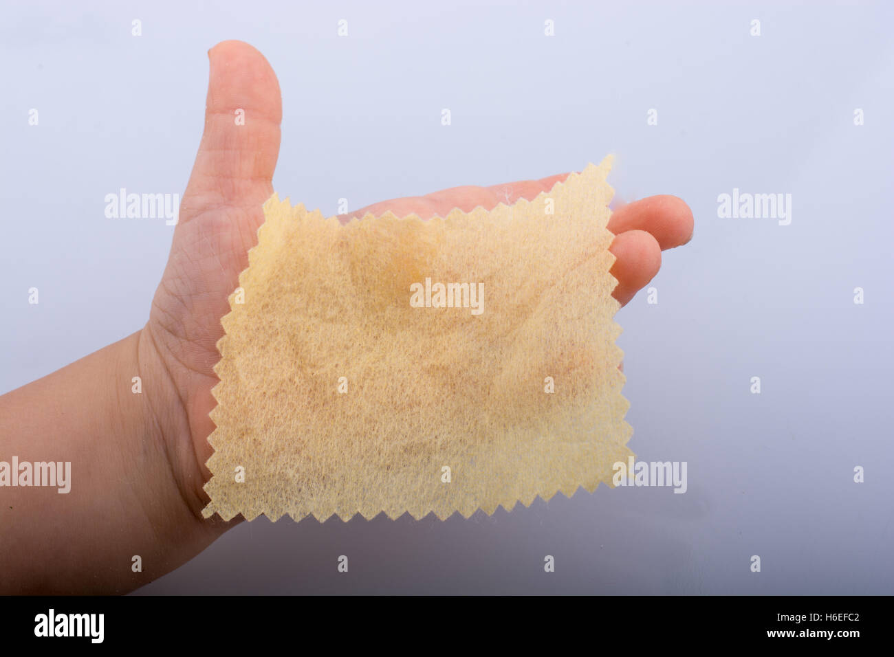 Yellow color mini handkerchief in hand on white background Stock Photo ...