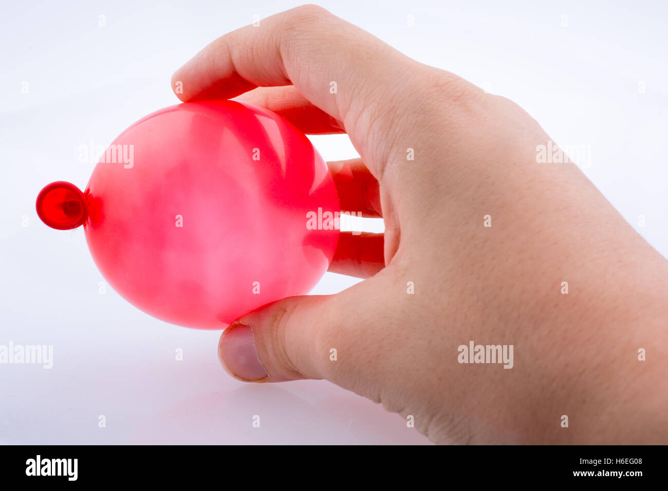 Hand holding a Colorful small balloon on a white background Stock Photo ...