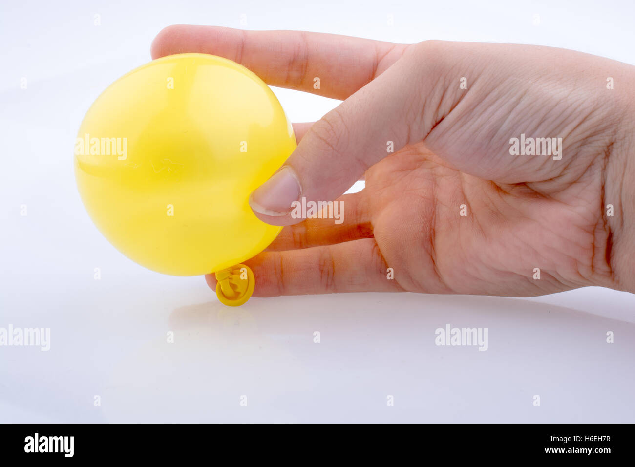Hand holding a Colorful small balloon on a white background Stock Photo ...