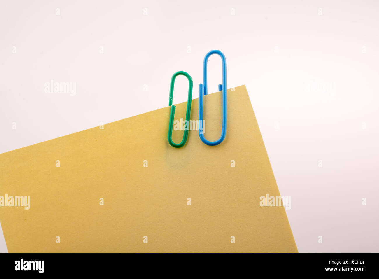 Hand holding a notepaper with paper clips on a white background Stock ...