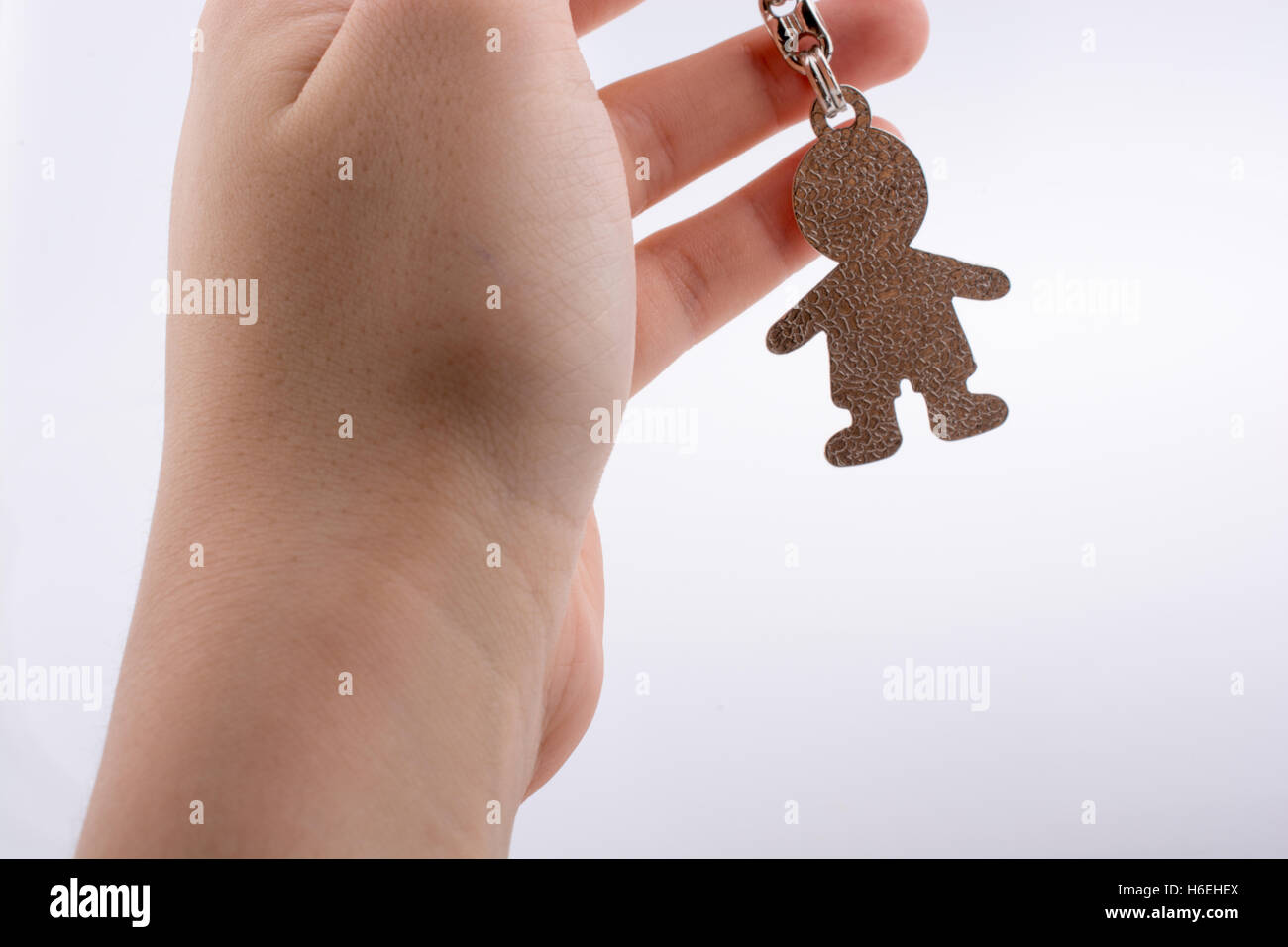 Man shaped keyholder in hand on white background Stock Photo - Alamy